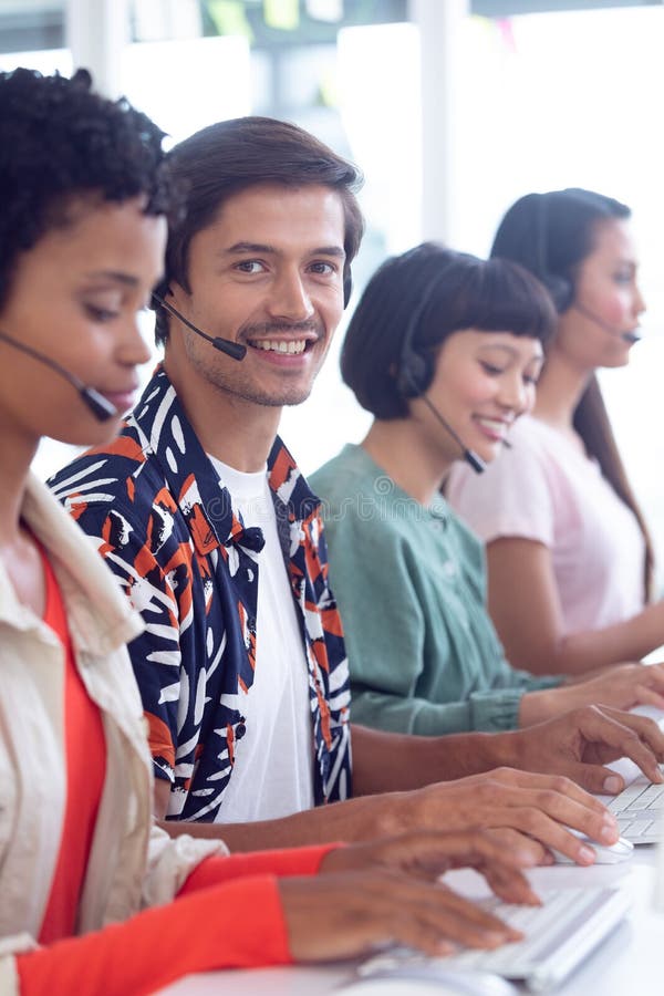 Male Customer Service Executive Working on Computer at Desk in Office ...
