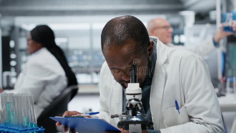 Male Cytotechnologist Using Optical Microscope To Study Microorganisms ...
