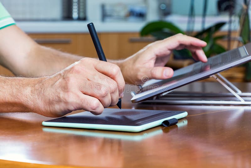 Male Designer Hands Using a Drawing Graphics Tablet and a Laptop while ...