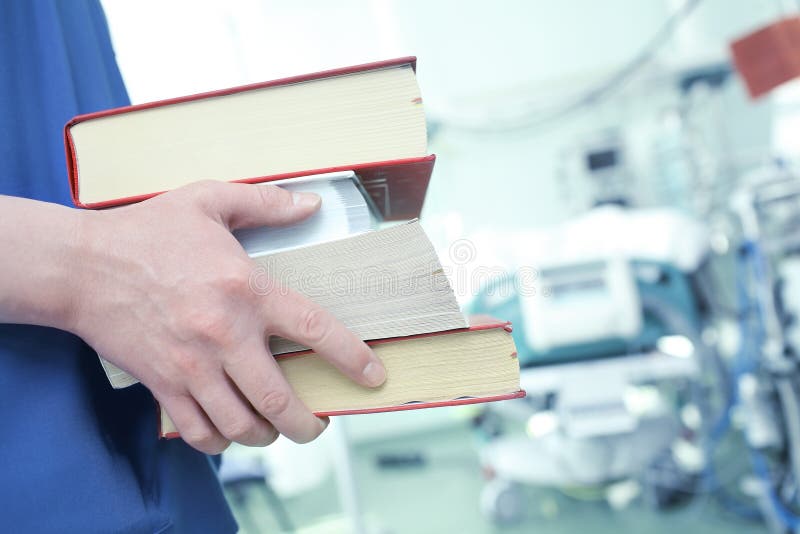 Male Doctor with Books in ICU Stock Photo - Image of health ...