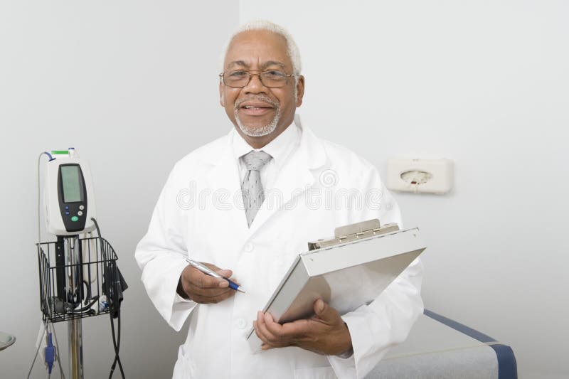 Male Doctor Holding Clipboard at Clinic Stock Image - Image of ...
