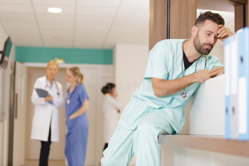 Male Doctor Leaning on Reception Desk Stock Photo - Image of clinic ...