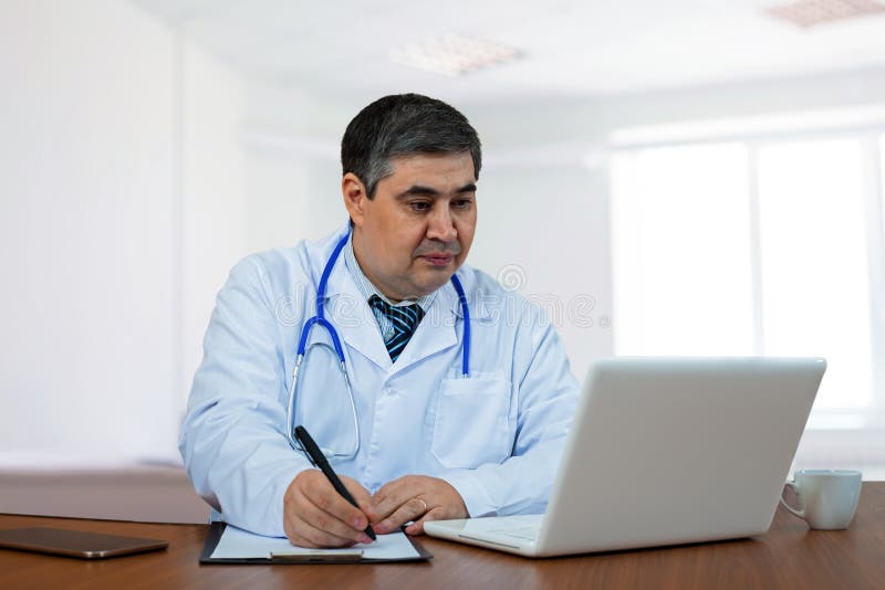 A Male Doctor is Looking at the Computer Stock Image - Image of desk ...