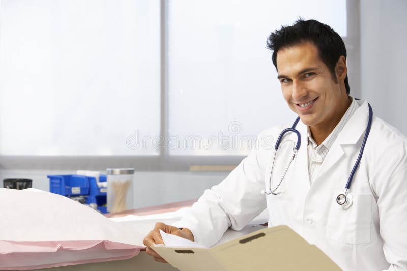 Male Doctor in Surgery Reading Patient Notes Stock Photo - Image of ...