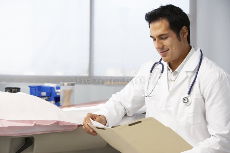 Male Doctor in Surgery Reading Patient Notes Stock Image - Image of ...