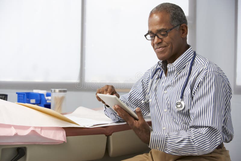 Male Doctor in Surgery Using Digital Tablet Stock Image - Image of ...