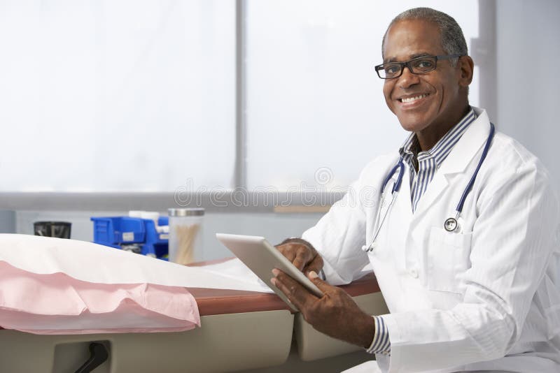 Male Doctor in Surgery Using Digital Tablet Stock Image - Image of ...