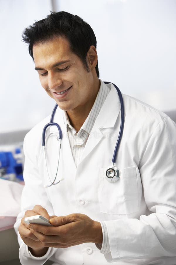 Male Doctor in Surgery Using Mobile Phone Stock Photo - Image of ...