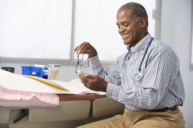 Male Doctor in Surgery Using Mobile Phone Stock Image - Image of office ...