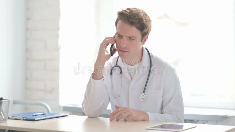Young Doctor Talking on Phone with Patient Stock Footage - Video of ...
