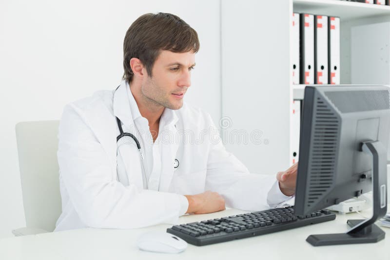 Male Doctor Using Computer at Medical Office Stock Photo - Image of ...