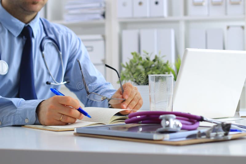 Male Doctor Using a Laptop, Sitting at His Desk Stock Photo - Image of ...