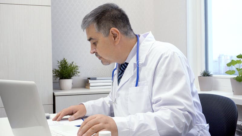 Male Doctor Working on Computer in Office Stock Photo - Image of laptop ...
