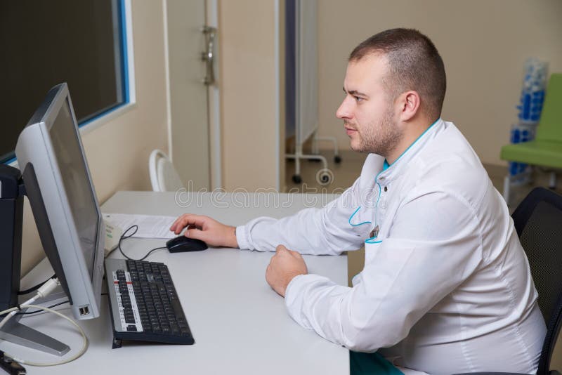 Male Doctor Working on Computer in Medical Clinic Stock Image - Image ...