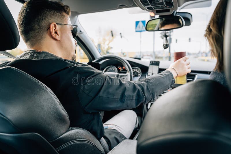 A Male Driver Takes a Bottle with a Drink Fixed in a Holder while ...