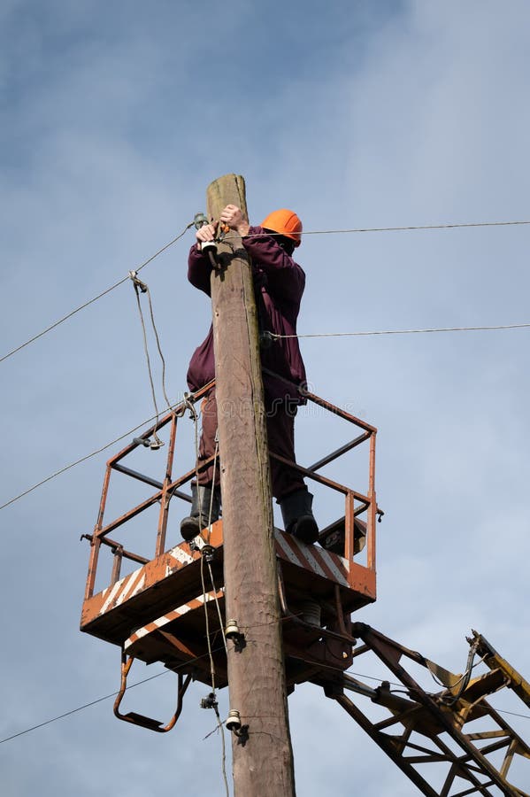 A Male Electrical Worker Repairs an Electrical Transmission Line. Stock ...