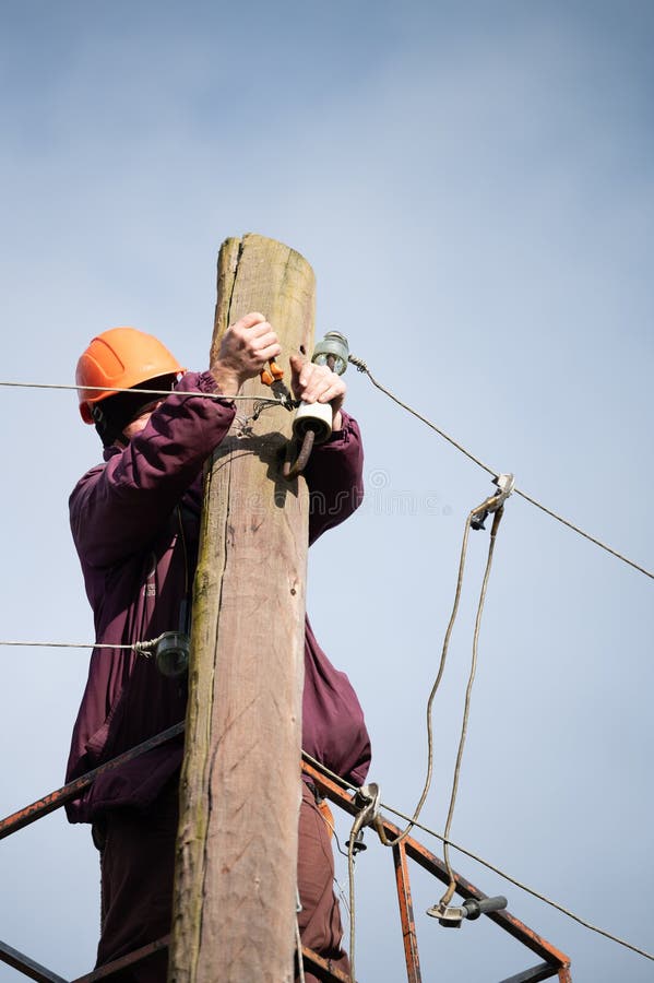 A Male Electrical Worker Repairs an Electrical Transmission Line. Stock ...
