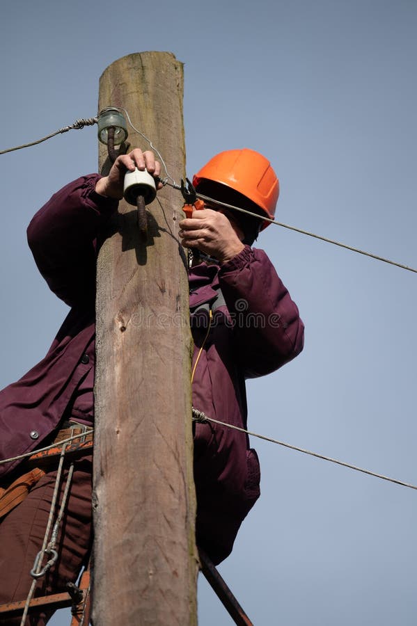 A Male Electrical Worker Repairs an Electrical Transmission Line. Stock ...