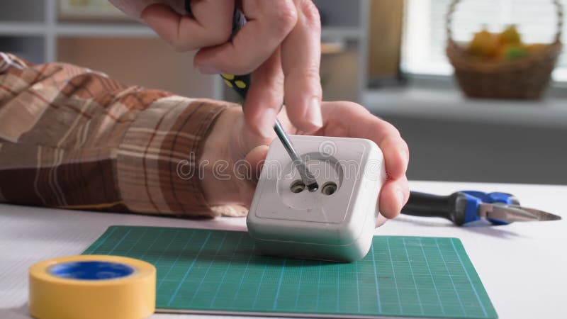 Male Electrician Using Screwdriver Unscrews the Bolt from the Socket on ...