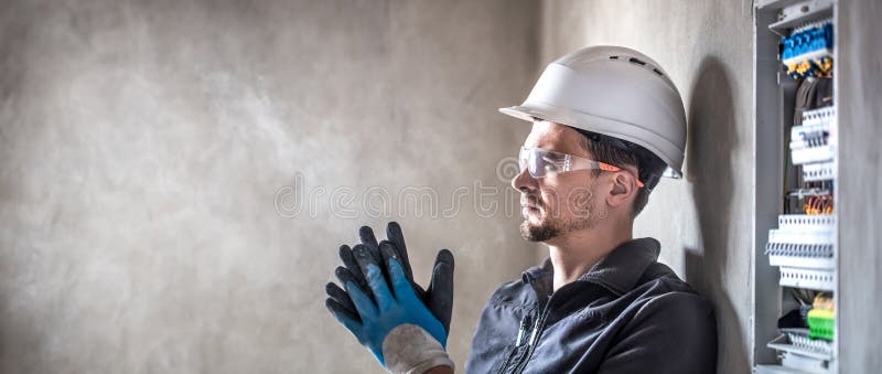 Male Electrician Working in Switchboard with Electrical Connection ...