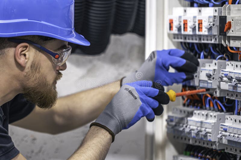 Male Electrician Working in a Switchboard with Fuses. Stock Photo ...
