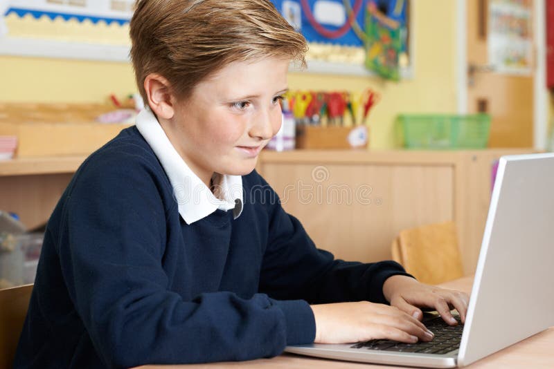 Male Elementary School Pupil Using Laptop in Computer Class Stock Photo ...