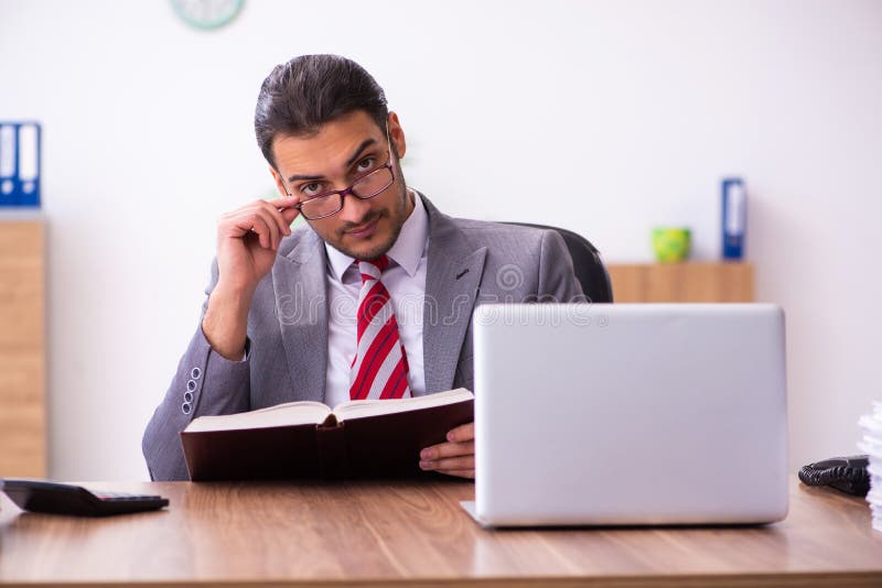 Young Male Employee Reading Book in the Office Stock Photo - Image of ...