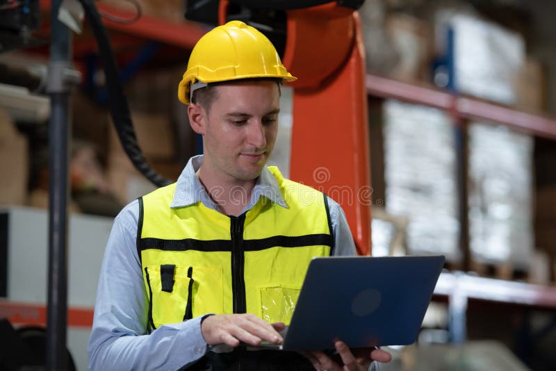 A Male Engineer Checking the Operation of a Welding Robot. Stock Image ...
