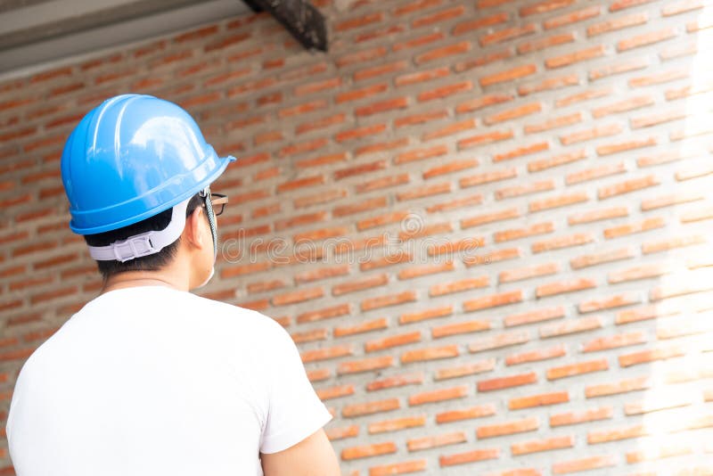 The Male Engineer is Checking the Walls Made of Red Bricks . Stock ...