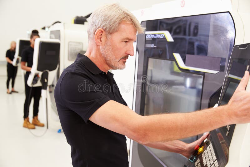 Male Engineer Operating CNC Machinery on Factory Floor Stock Photo ...