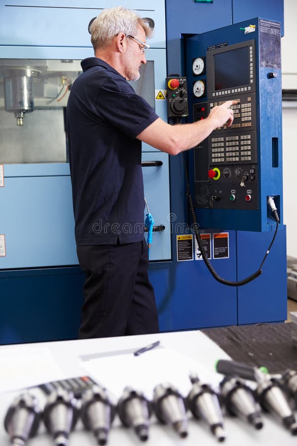 Male Engineer Operating CNC Machinery on Factory Floor Stock Photo ...