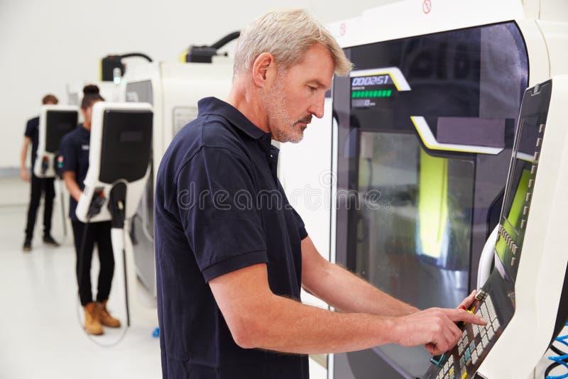 Male Engineer Operating CNC Machinery on Factory Floor Stock Photo ...