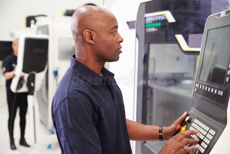 Male Engineer Operating CNC Machinery on Factory Floor Stock Photo ...