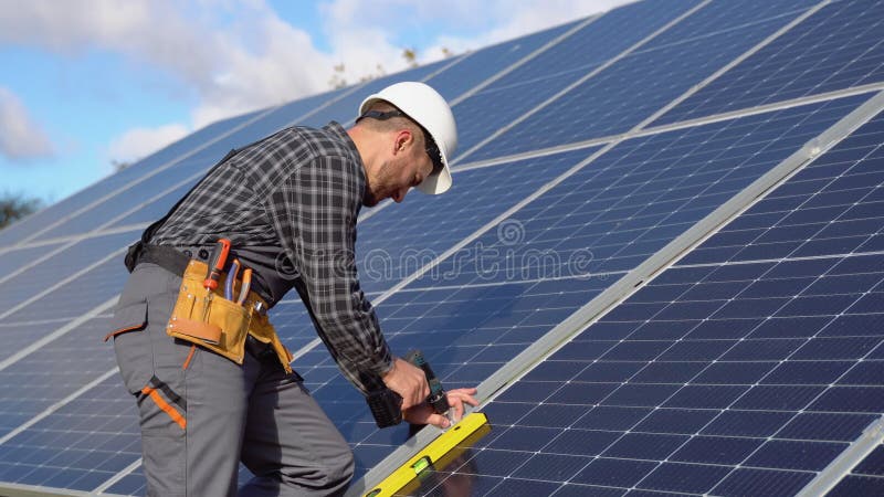 Male Engineer in Protective Helmet Installing Solar Photovoltaic Panel ...