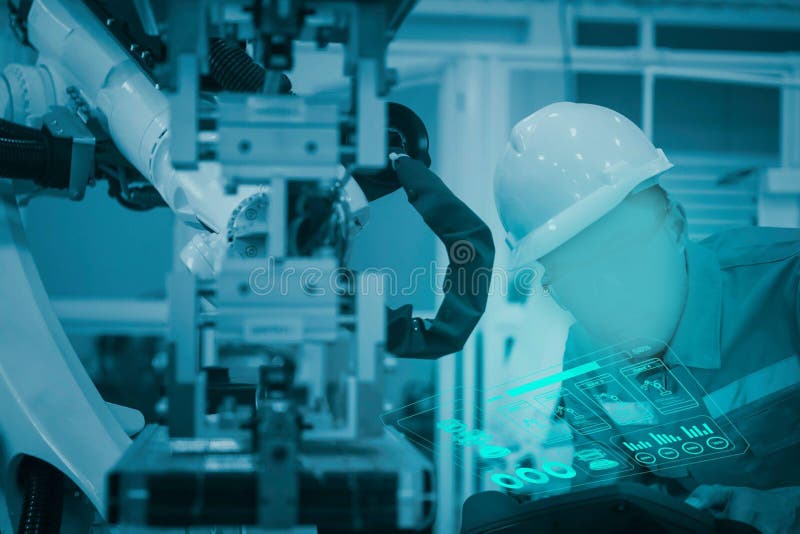 A Male Engineer Uses a Remote Control To Control a Robotic Arm Working ...