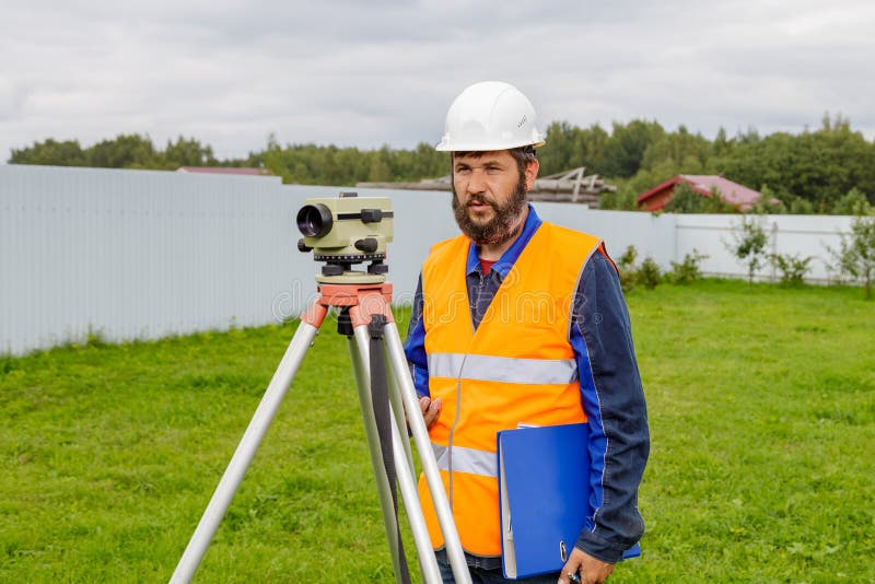 A Male Engineer Works with the Optical Level on Site. Stock Photo ...