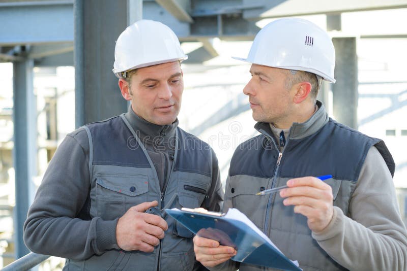 2 Male Engineers with Clipboard Looking at Clipbord Stock Image - Image ...