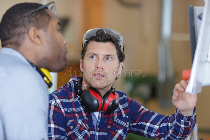 Male Engineers with Technical Drawing Operating Cnc Machine in Factory ...