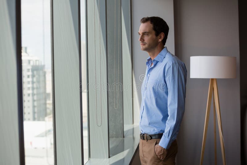 Male Executive Looking through Window in Office Stock Image - Image of ...