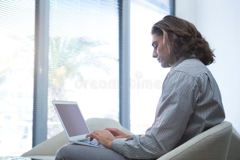 Male Executive Using Laptop in Waiting Area Stock Image - Image of area ...