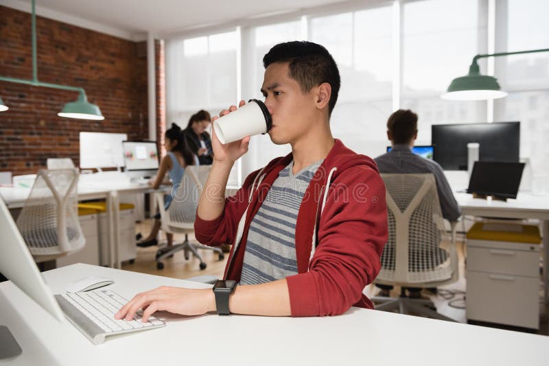 Male Executive Working on Computer while Having Coffee Stock Image ...