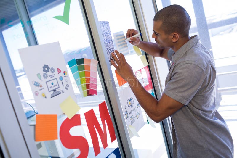 Male Executive Reading Sticky Notes on Glass Door Stock Photo - Image ...