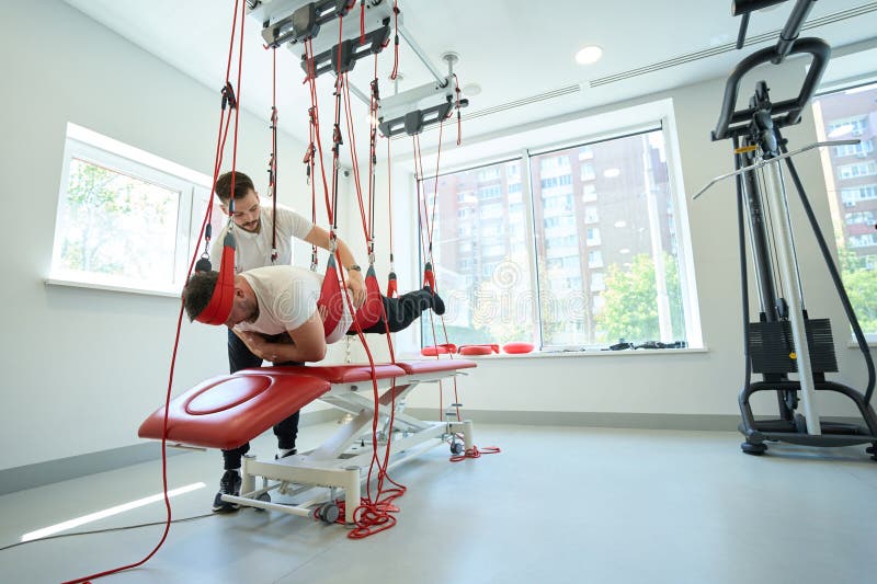 Male Exercising on Suspension-based Training System Supervised by ...