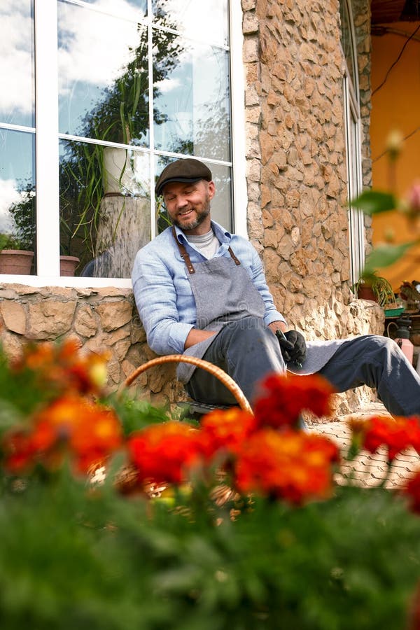 A Male Farmer Sitting in the Yard Outdoors, Resting. Stock Image ...
