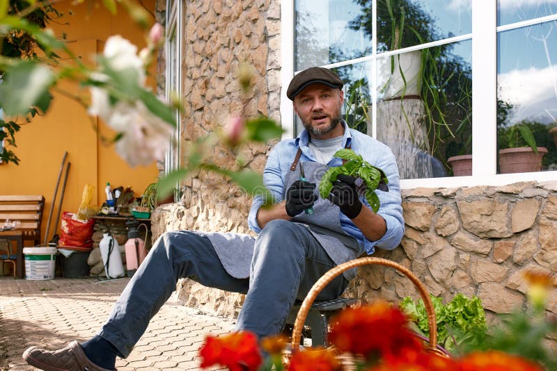 A Male Farmer Sitting in the Yard Outdoors, Resting. Stock Photo ...