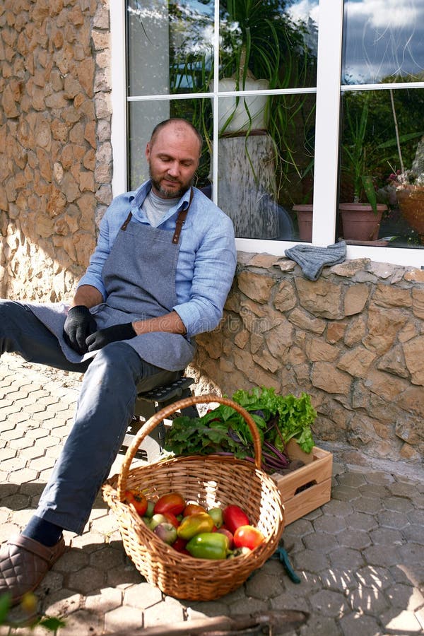 A Male Farmer Sitting in the Yard Outdoors, Resting. Stock Image ...