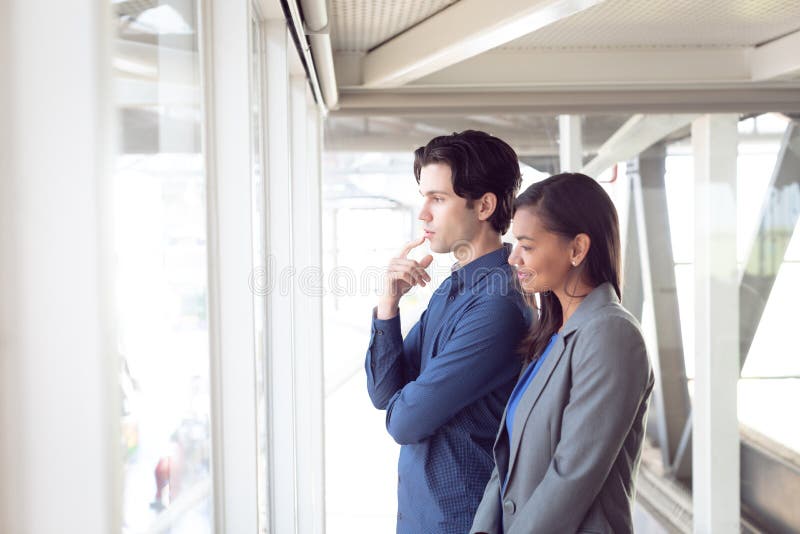 Male and Female Architects Looking through Window in Office Stock Image ...
