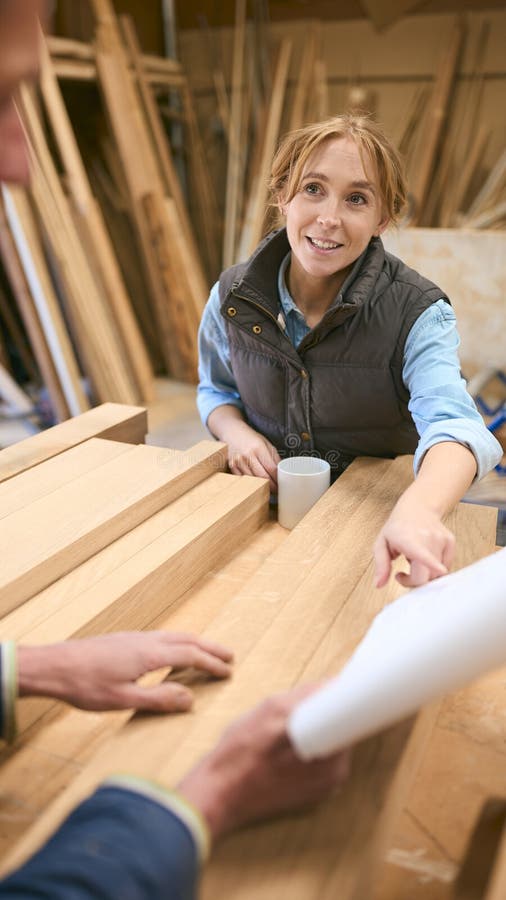 Male and Female Carpenter Working in Woodwork Workshop Discussing Plan ...