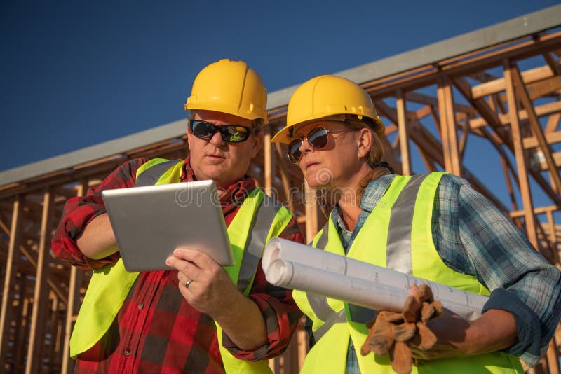 Male and Female Construction Workers Using Computer Pad Stock Image ...