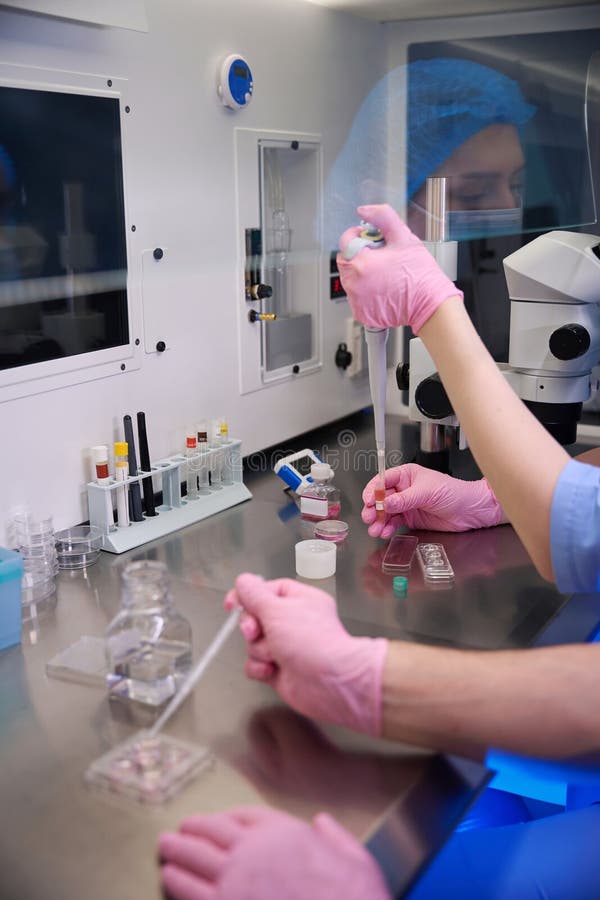 Male and Female Embryologists Performing Lab Task with Coordinated ...